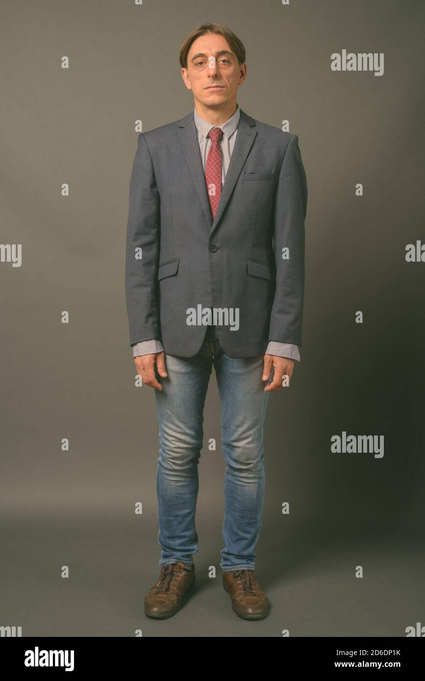 Mature handsome Italian businessman against gray background Stock Photo ...
