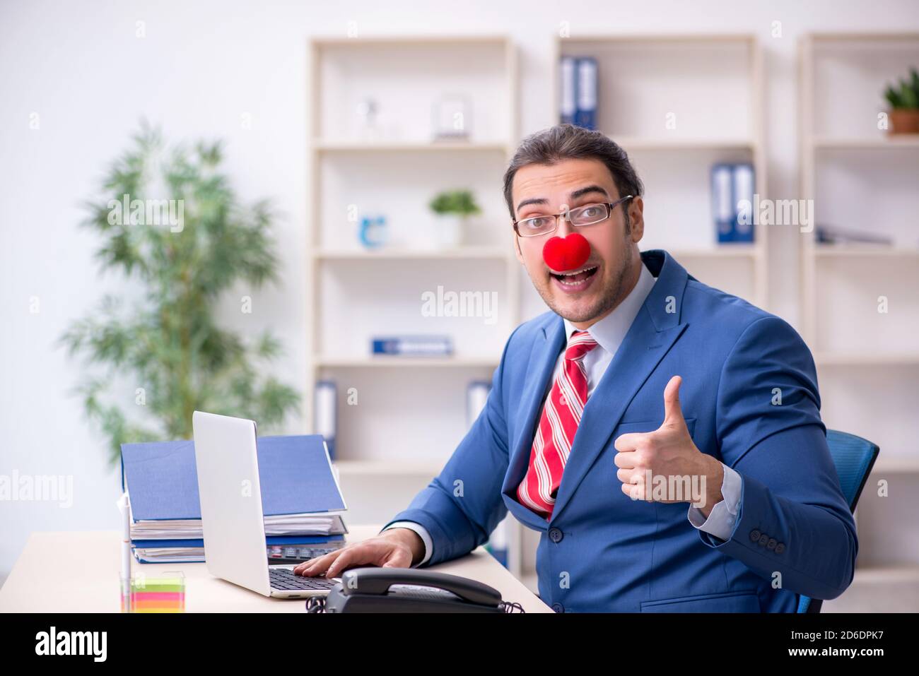 Funny employee clown working in the office room Stock Photo - Alamy