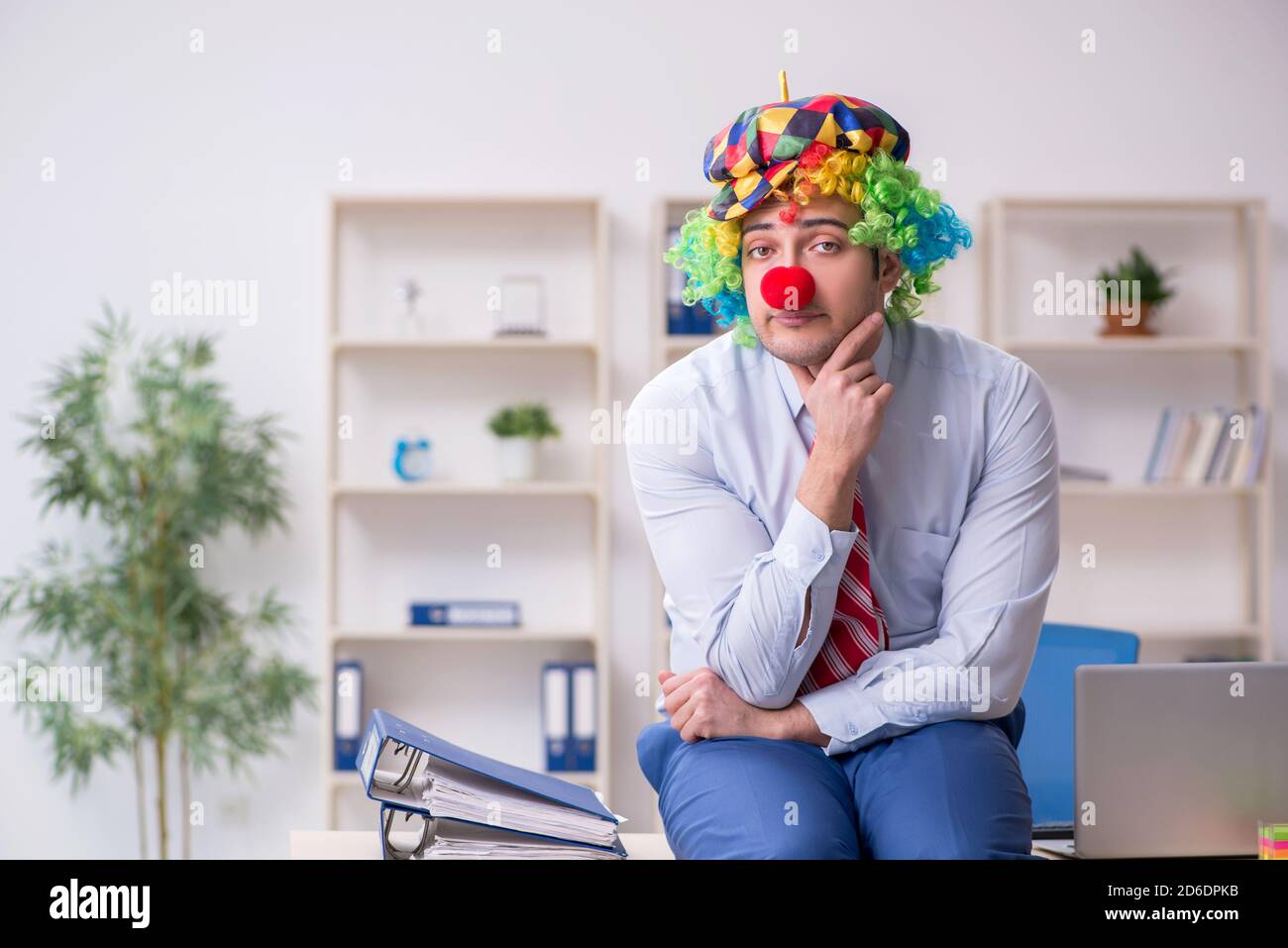 Funny employee clown working in the office room Stock Photo - Alamy