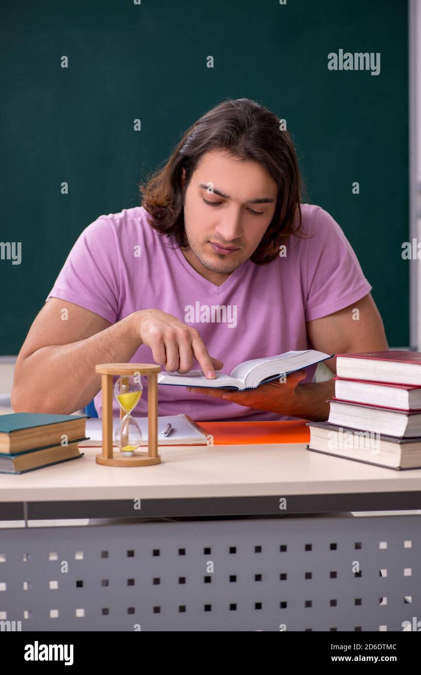 Young student in the classroom at time management concept Stock Photo ...