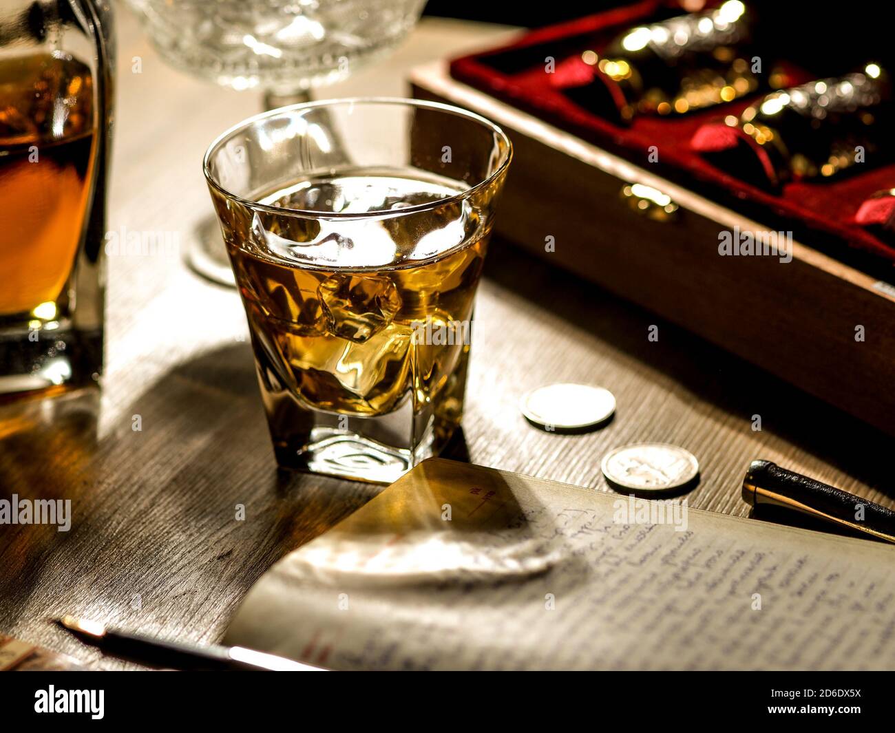 Glass of whisky, books and diary late at night Stock Photo - Alamy