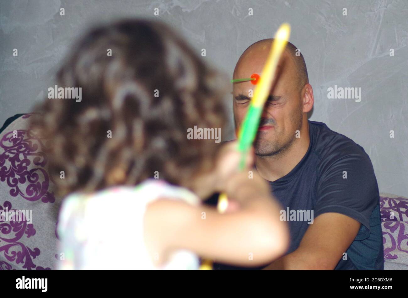 a baby archer shooting at her daddy with toy bow and arrows Stock Photo ...