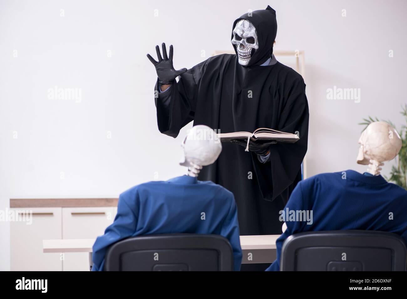 Funny business meeting with the devil and skeletons Stock Photo - Alamy