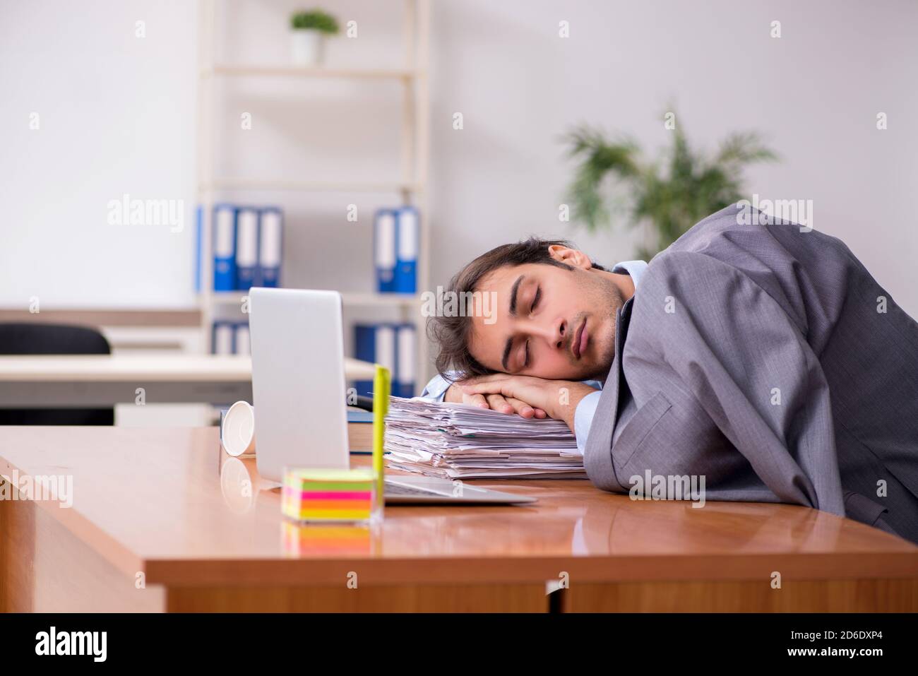 Young employee sleeping in the office Stock Photo - Alamy
