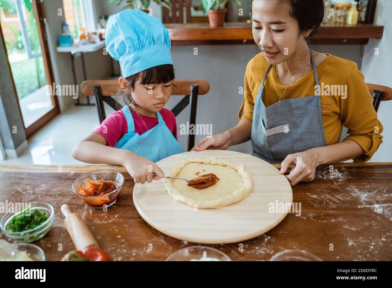 Excited two female generations family enjoying cooking process together ...