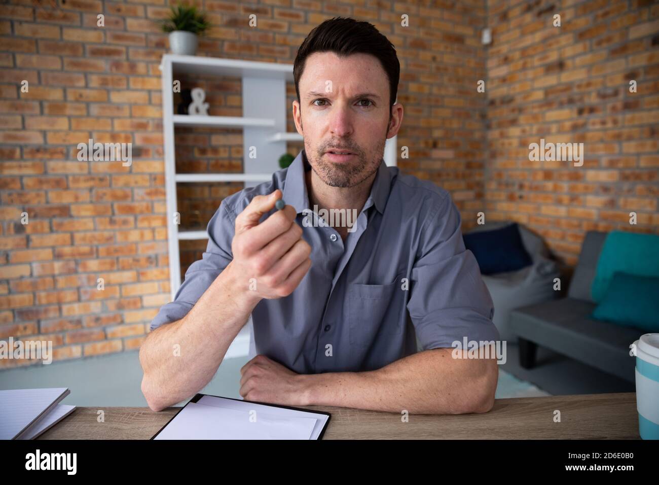 Portrait of man making hand gestures while sitting on his desk Stock ...