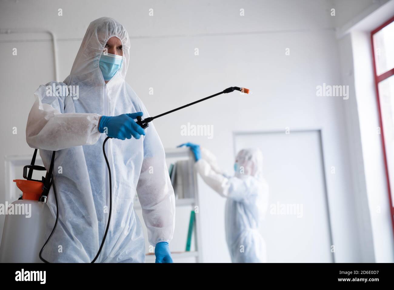 Health worker wearing protective clothes cleaning using disinfectant ...