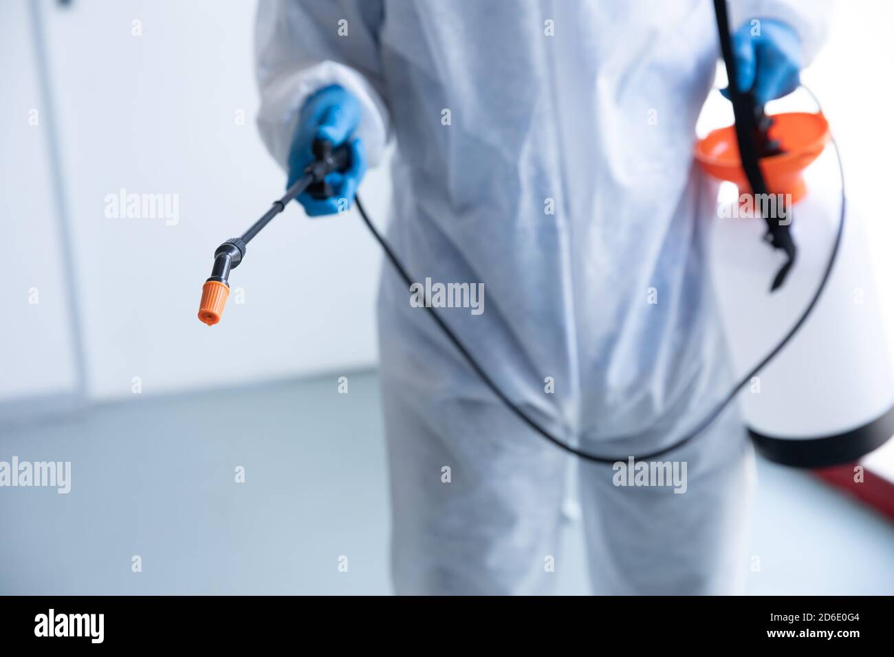 Mid section of health worker wearing protective clothes cleaning using ...
