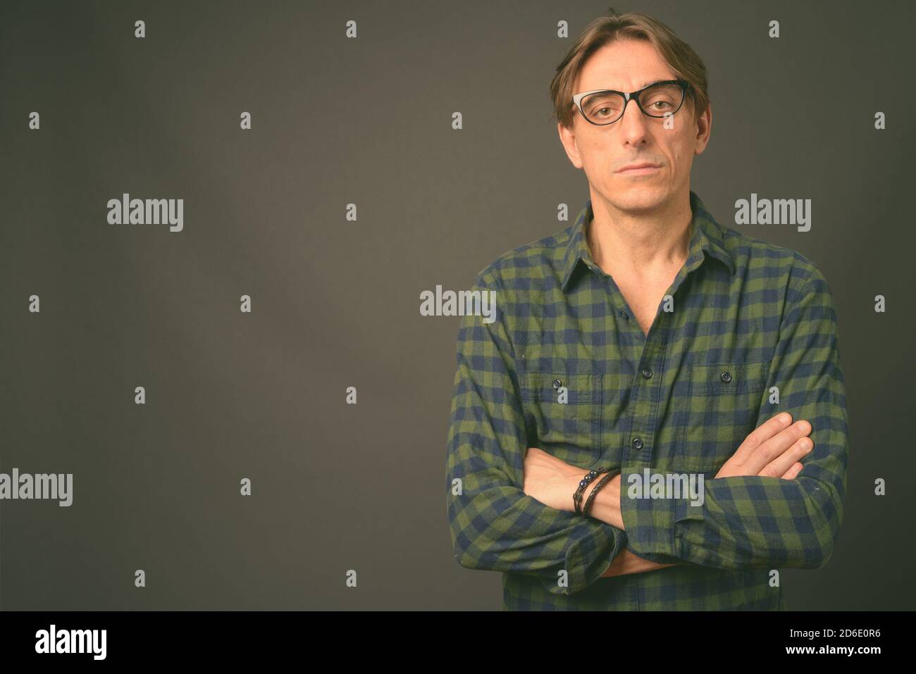 Mature handsome Italian man against gray background Stock Photo - Alamy
