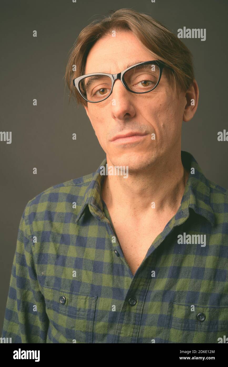 Mature handsome Italian man against gray background Stock Photo - Alamy