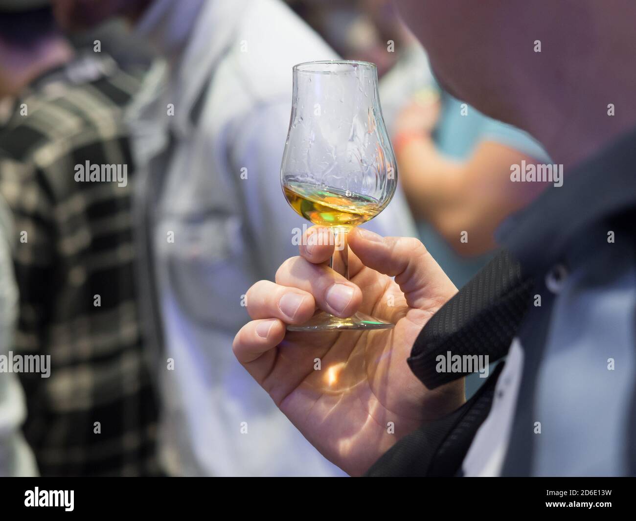 Hand holding a whisky tasting glass Stock Photo - Alamy