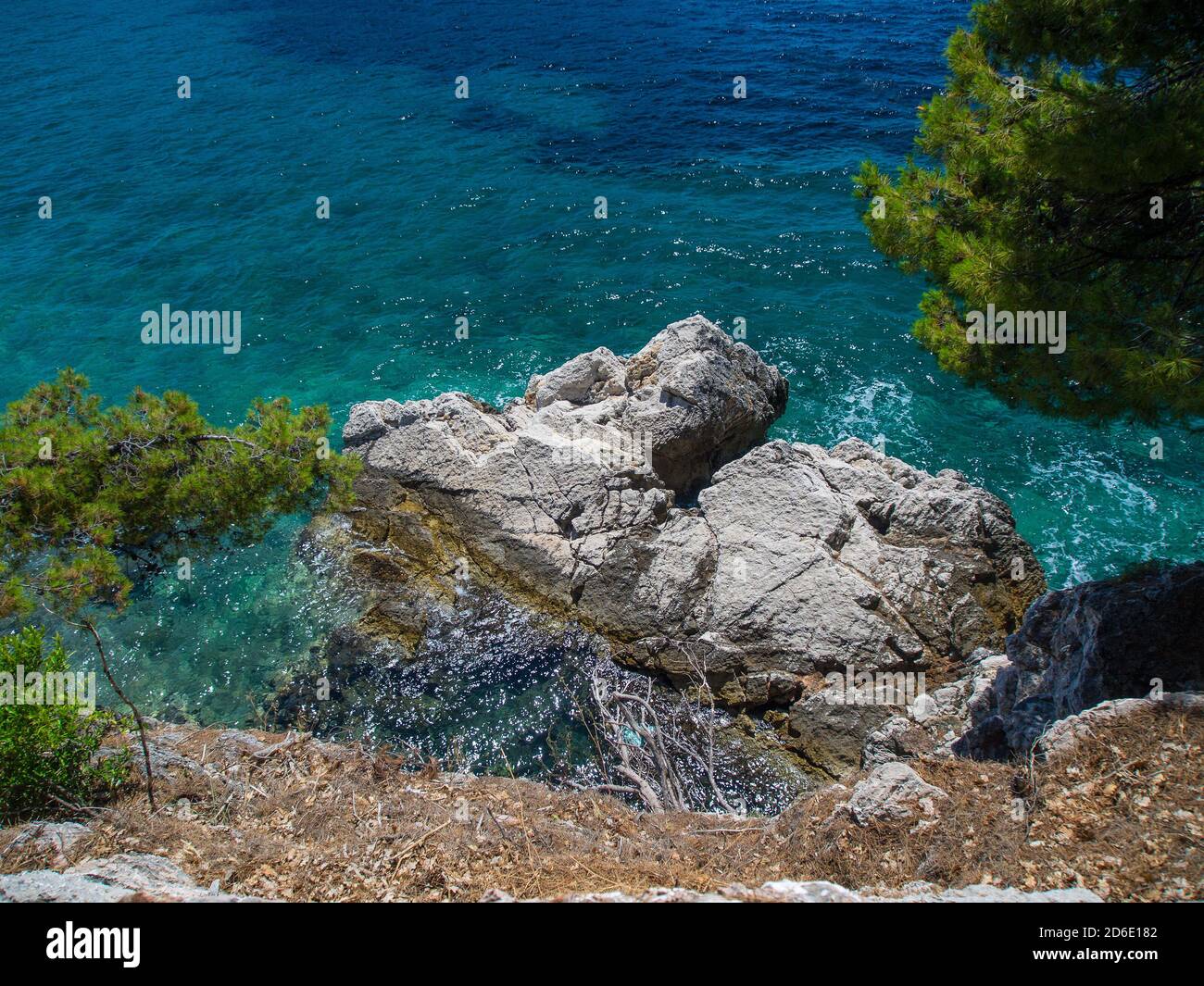 Blue and azure sea waters and rocky cliff Stock Photo - Alamy