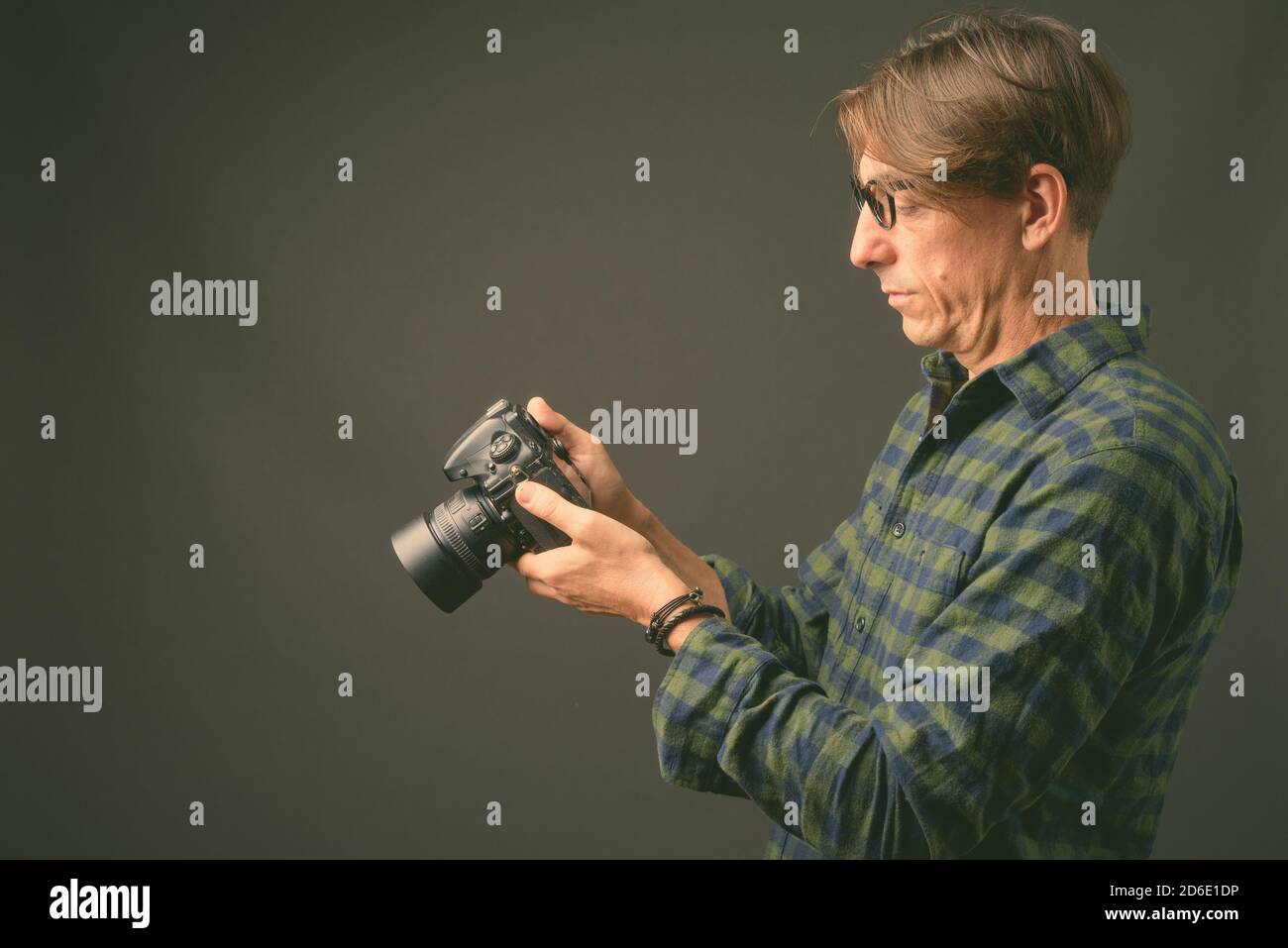 Mature handsome Italian man against gray background Stock Photo - Alamy