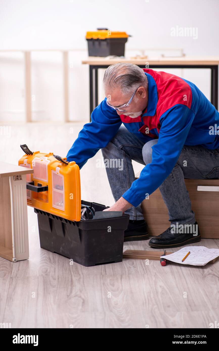 Old carpenter working indoors on furniture Stock Photo - Alamy