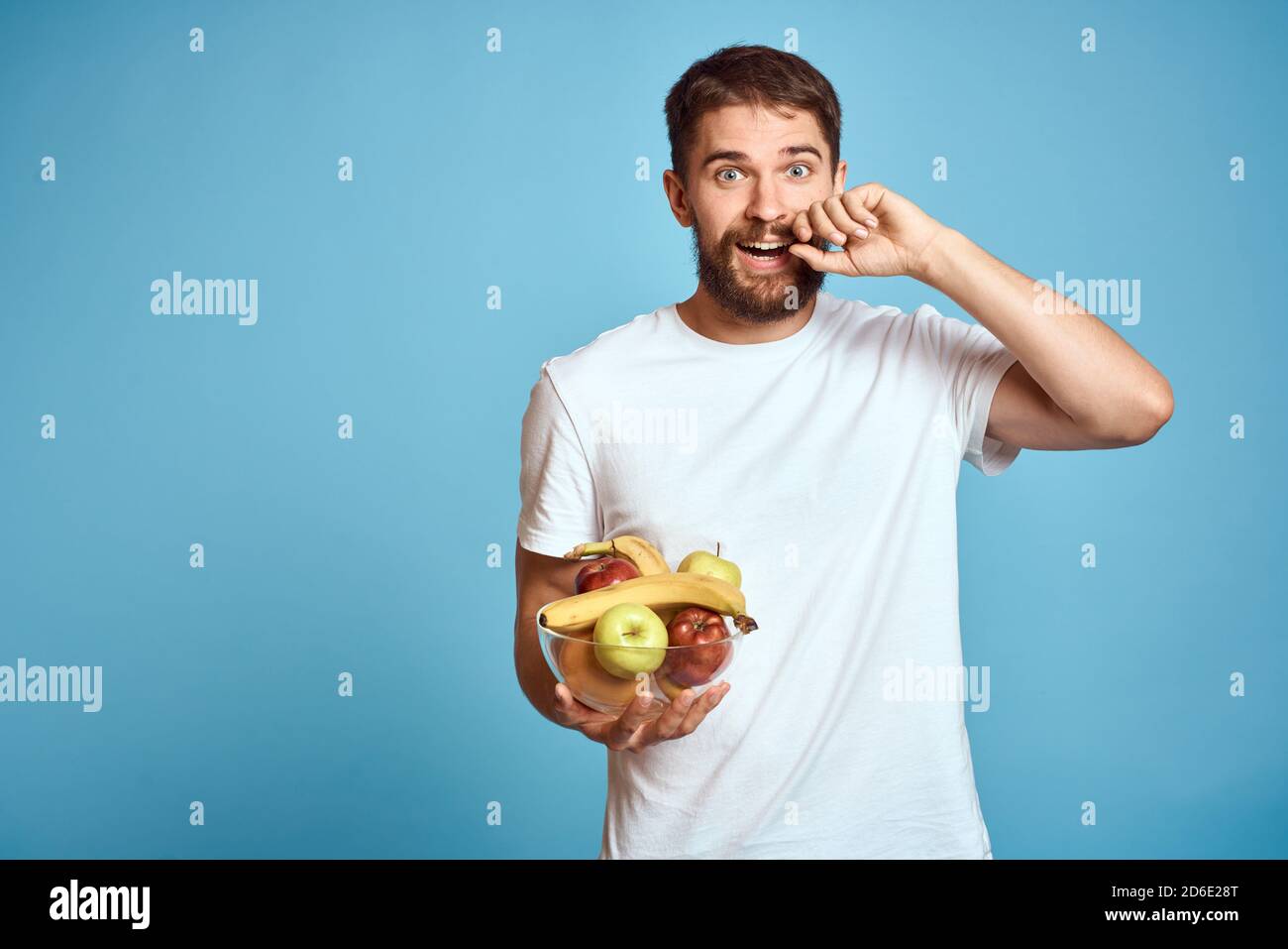 dark background handsome man with a beard holding fresh fruit and ...