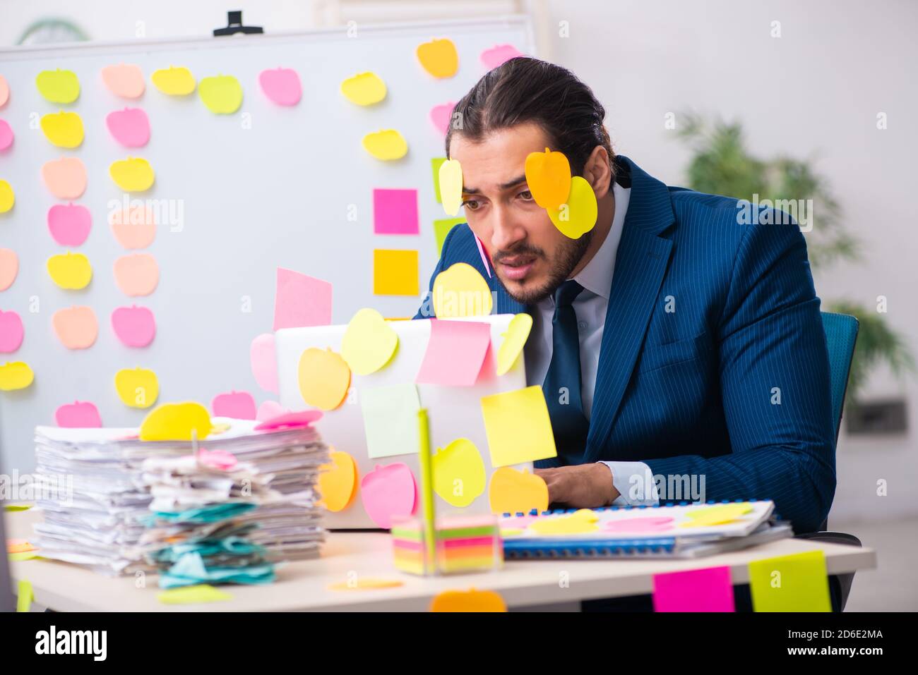 Young employee in conflicting priorities concept Stock Photo - Alamy