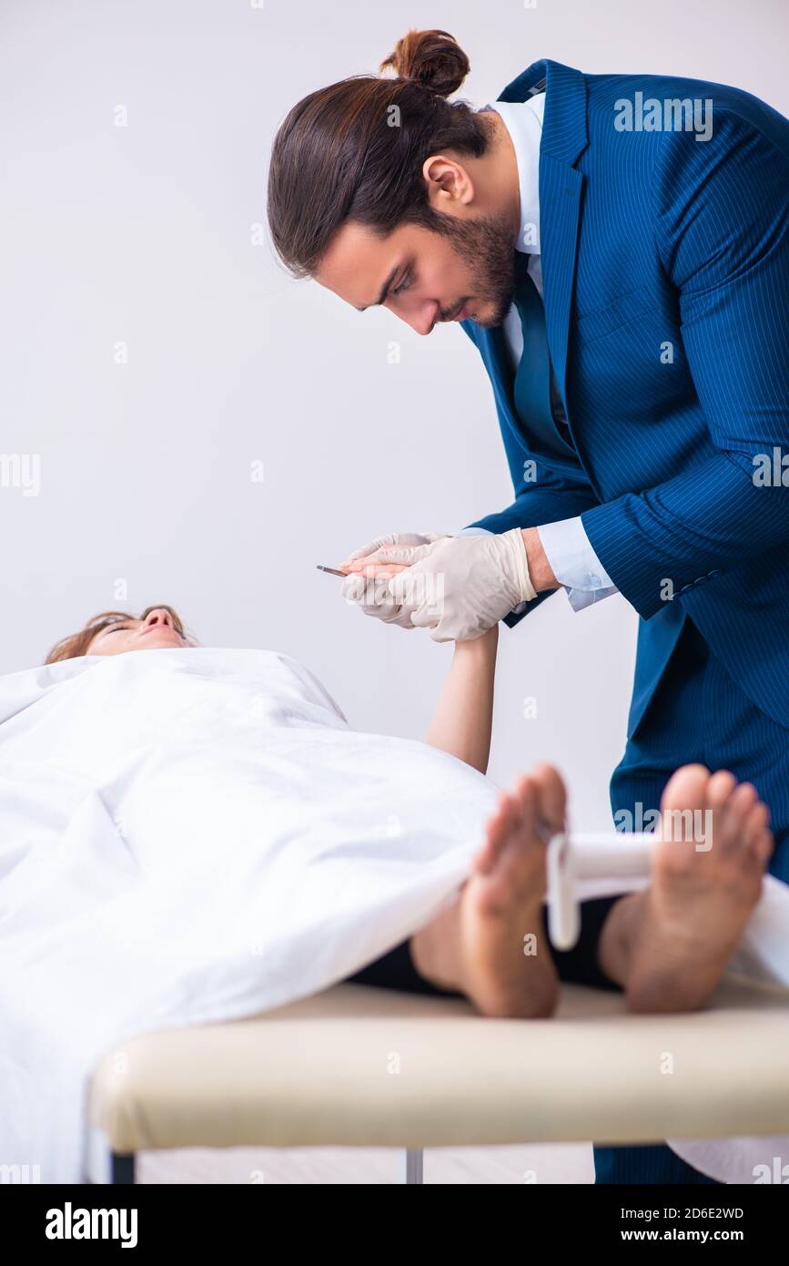 Police coroner examining dead body in morgue Stock Photo - Alamy