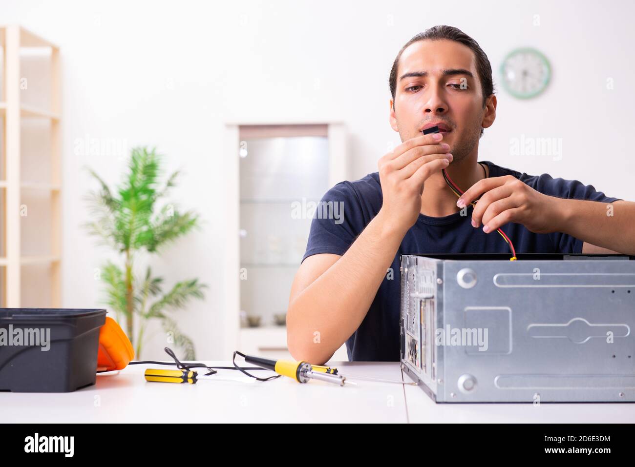 Young man repairing computer at the home Stock Photo - Alamy