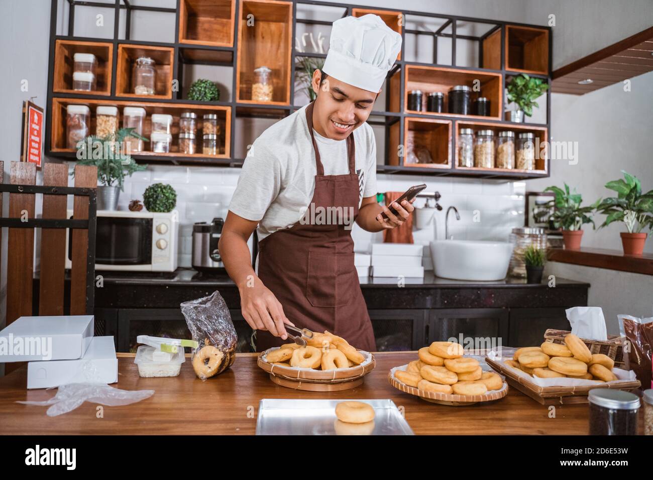 Chef male prepare donuts in the kitchen. Professional male holds a ...
