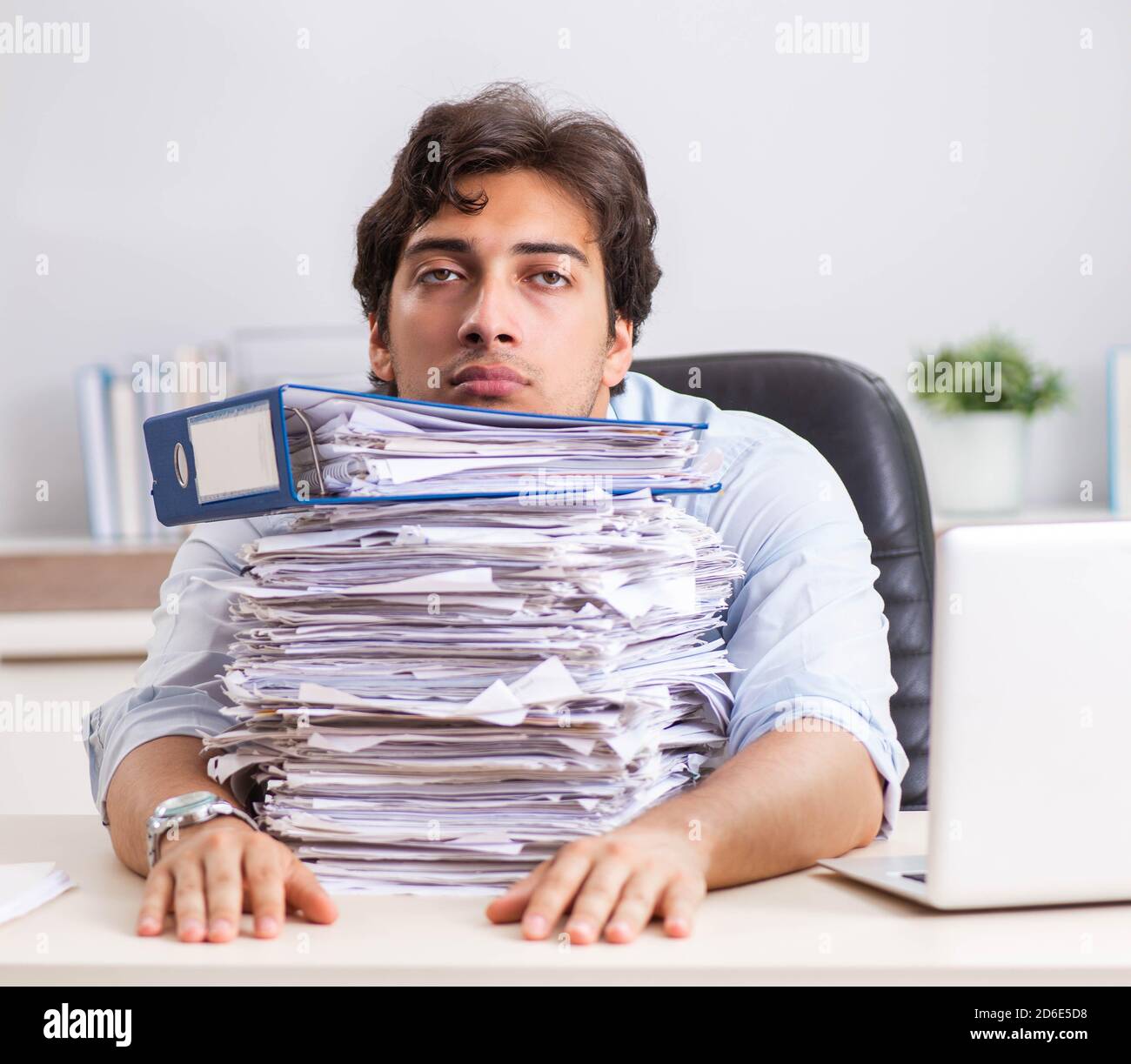 The overloaded busy employee with too much work and paperwork Stock ...