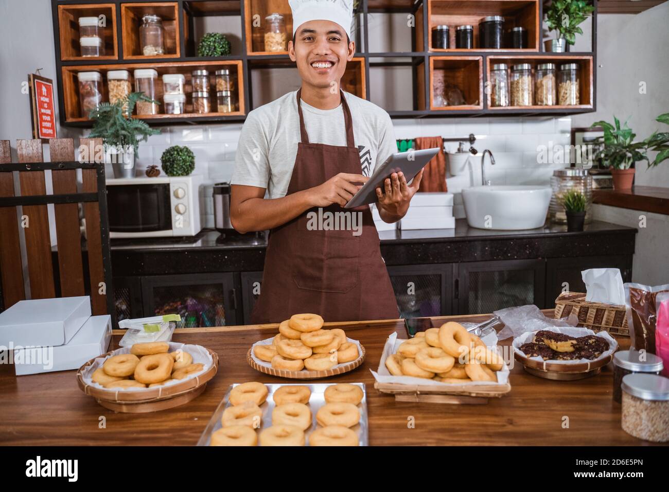 Chef male prepare orders of donuts in the kitchen. The professional ...