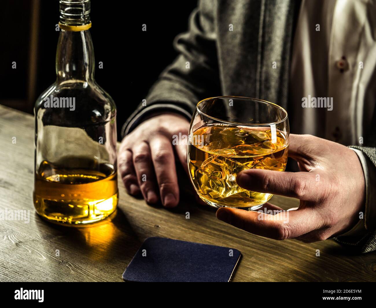 Man wearing jacket holding a glass of whiskey at the bar counter Stock ...