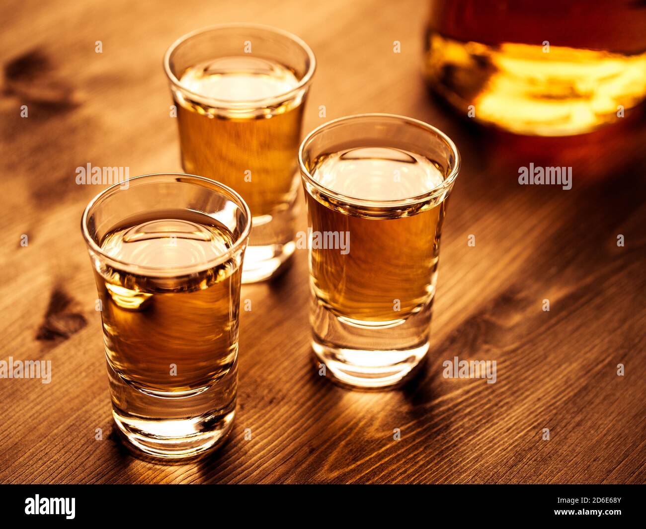 Three shots and a bottle on a table Stock Photo - Alamy