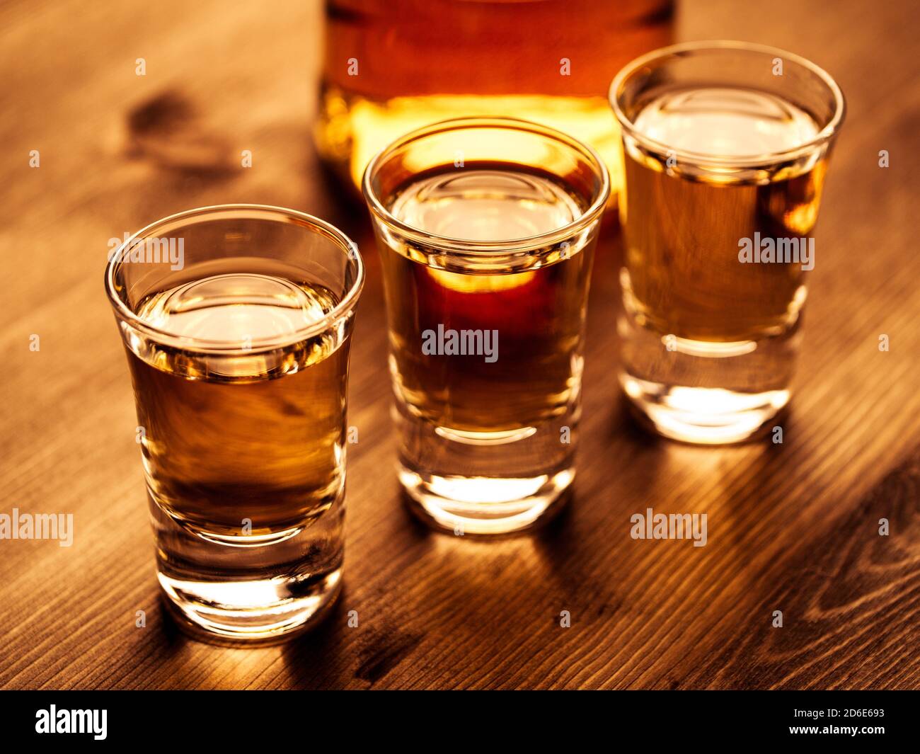Three shots and a bottle on a table Stock Photo - Alamy