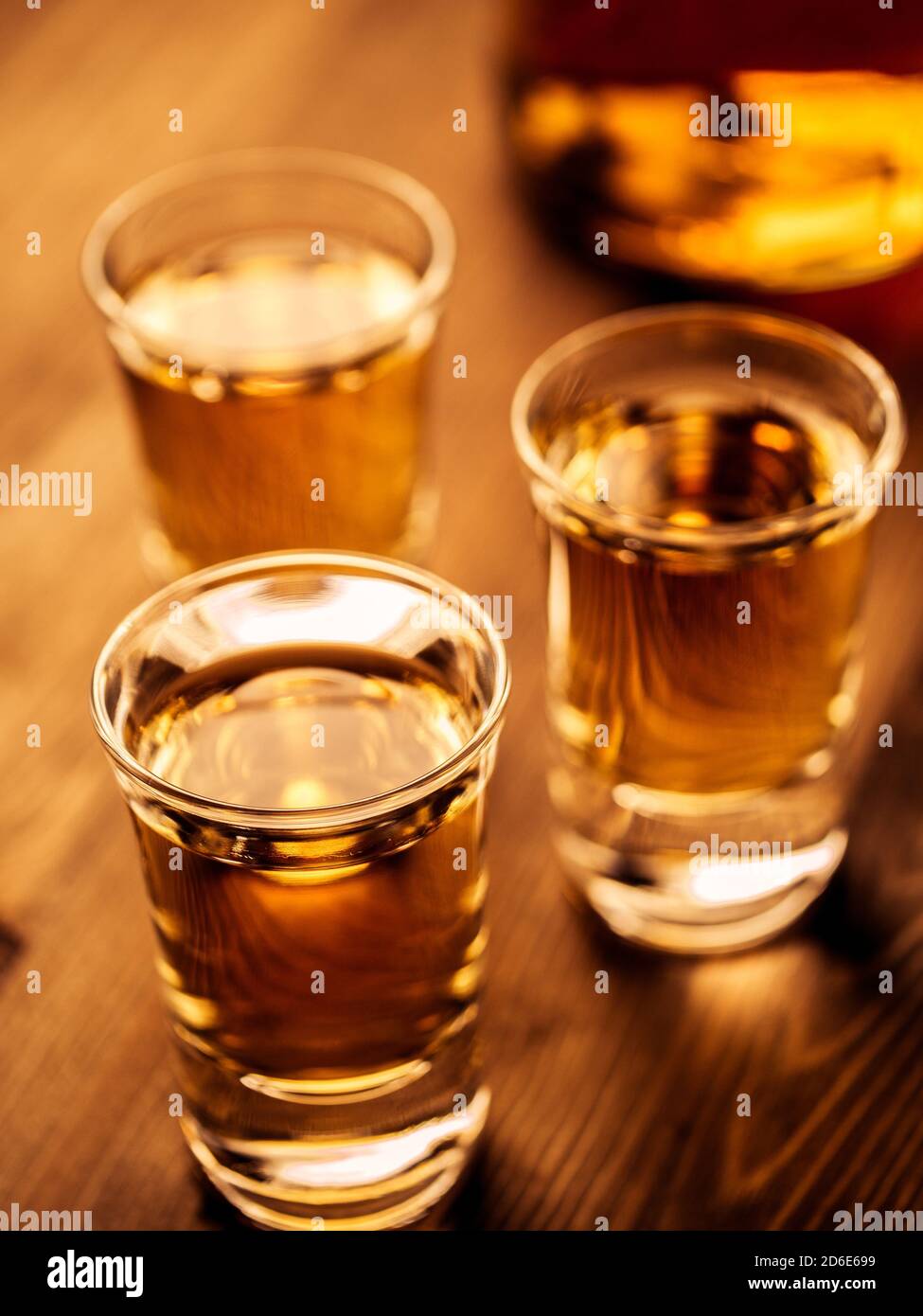 Three shots and a bottle on a table Stock Photo - Alamy
