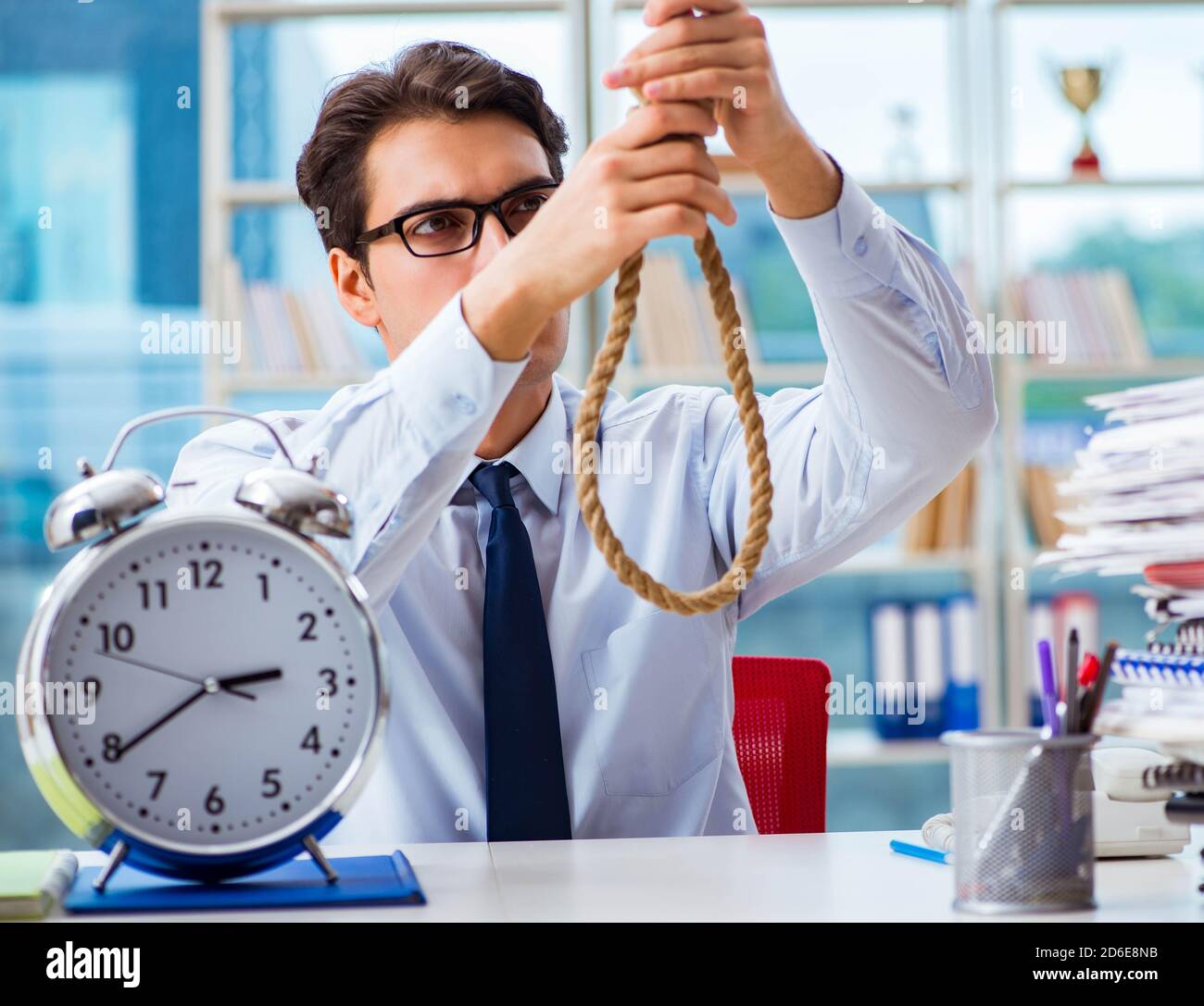 The unhappy businessman thinking of hanging himself in the office Stock ...