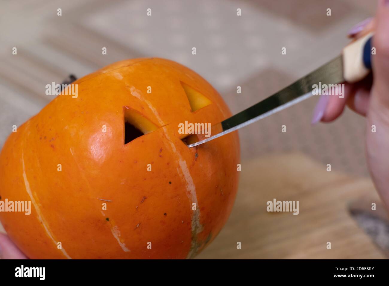 the process of making a Halloween pumpkin. cutting nose. horror theme ...