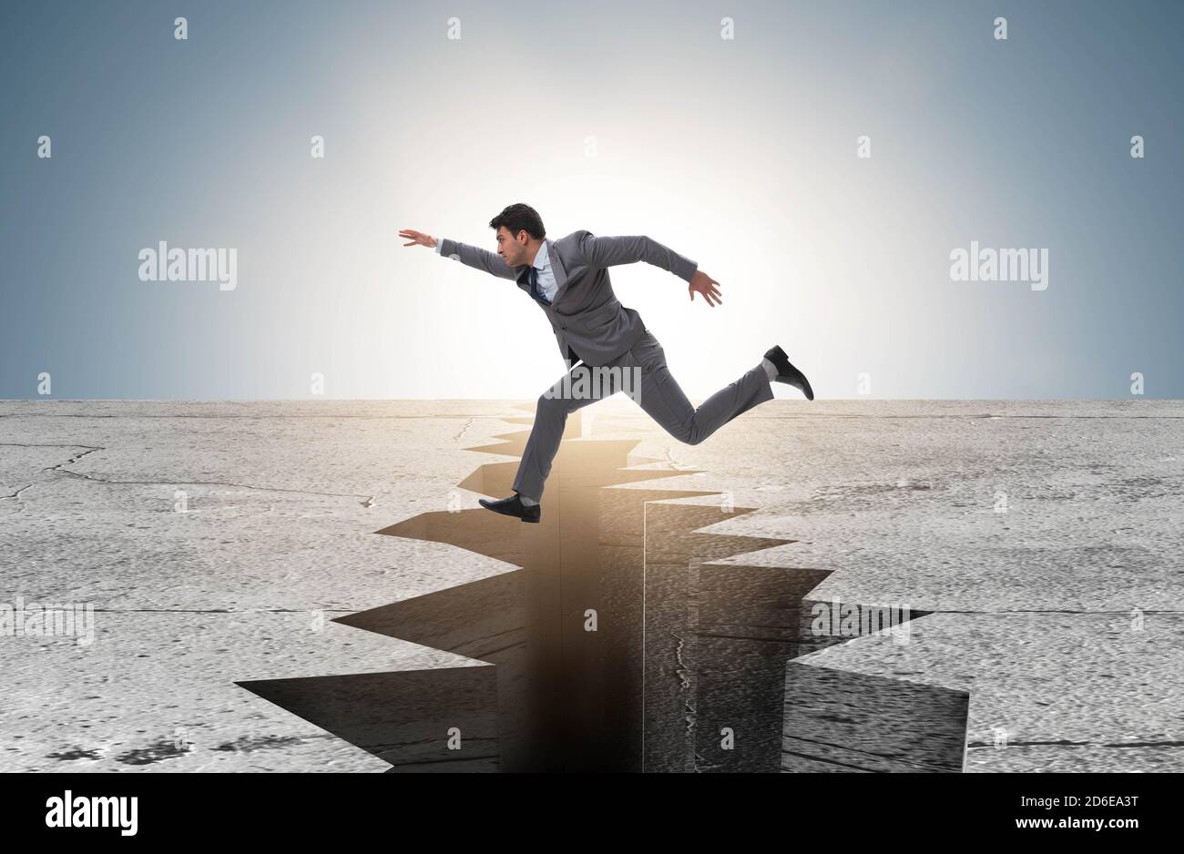 The businessman jumping over the cliff Stock Photo - Alamy