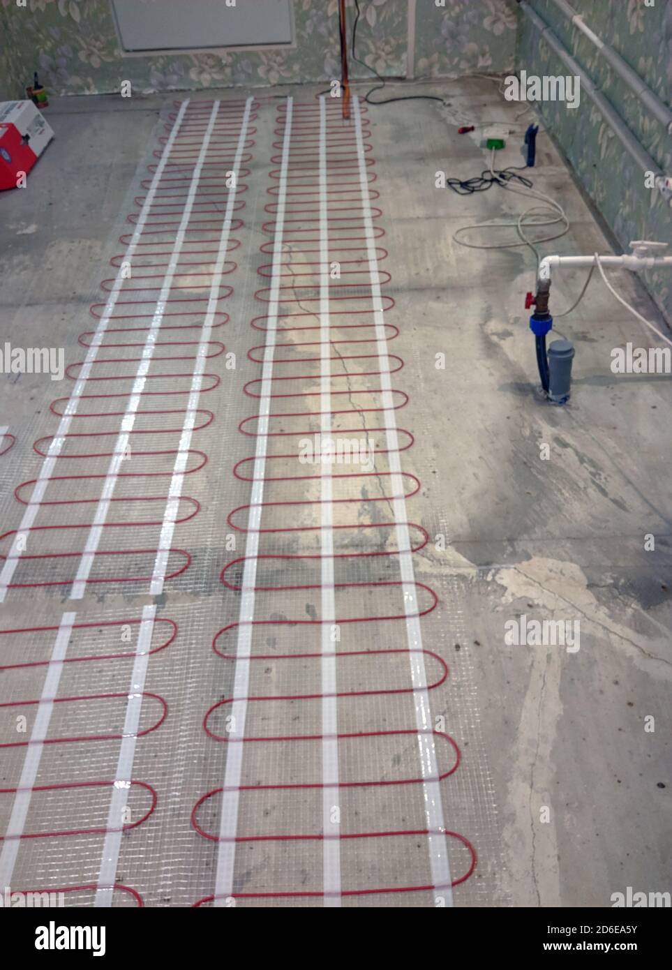 Closeup of concrete and red electrical wires. Electric floor heating ...