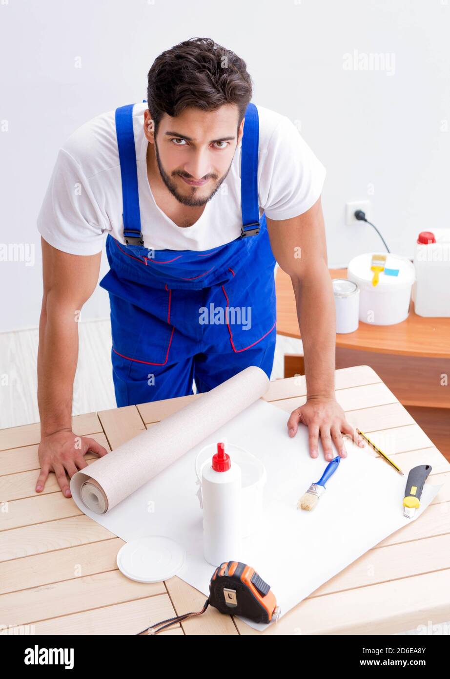 The worker working on wallpaper during refurbishment Stock Photo - Alamy