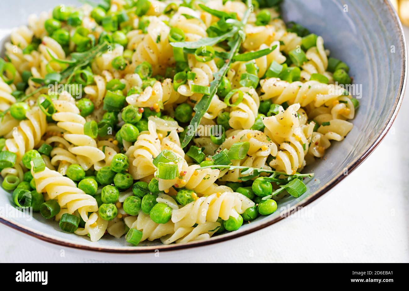 Vegan salad. Fusilli pasta with green peas and onions. Italian food ...