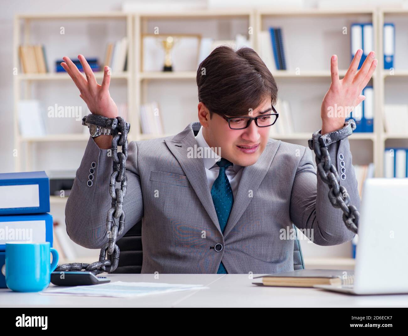 The businessman tied with chains to his work Stock Photo - Alamy