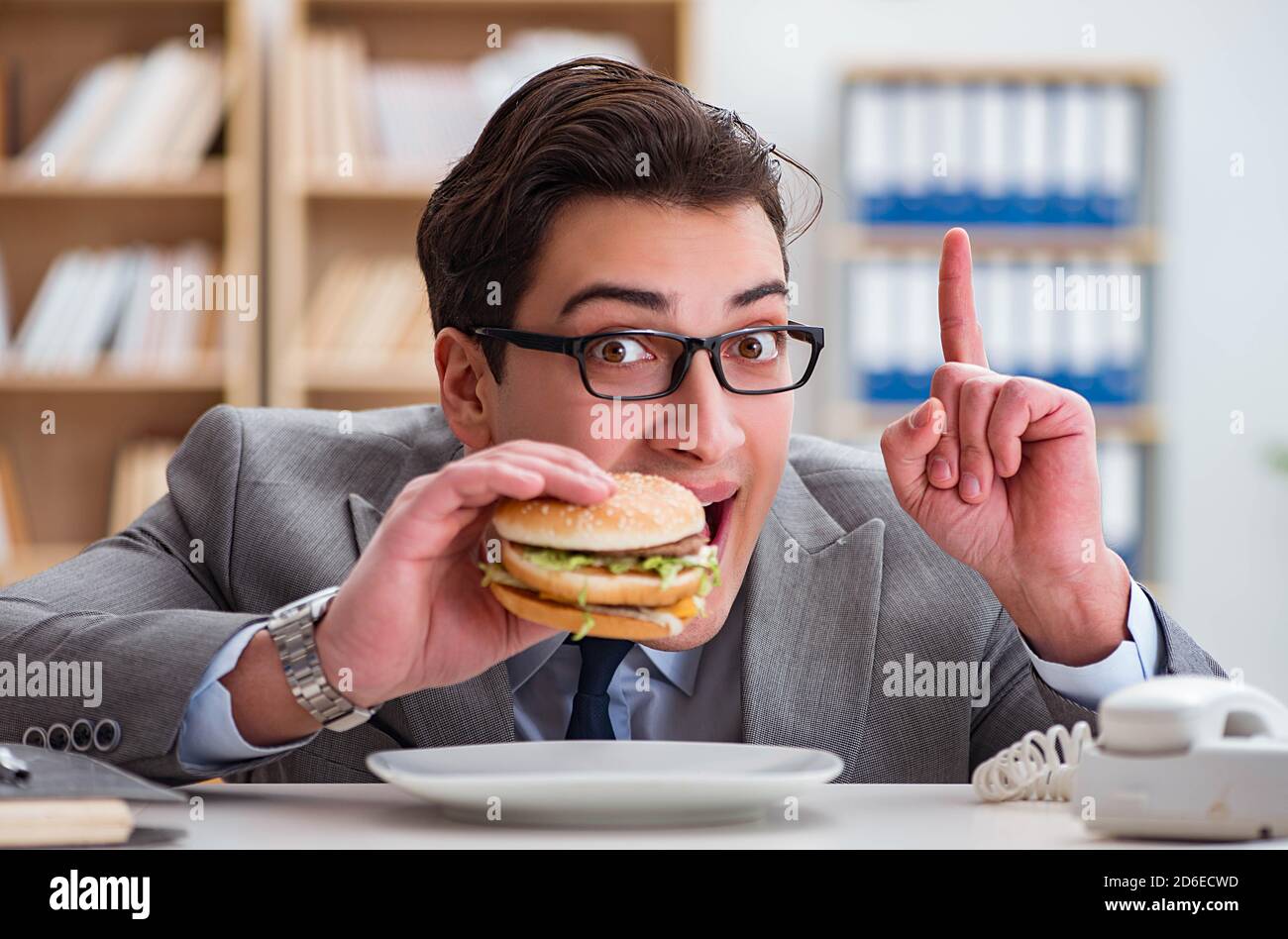 The hungry funny businessman eating junk food sandwich Stock Photo - Alamy