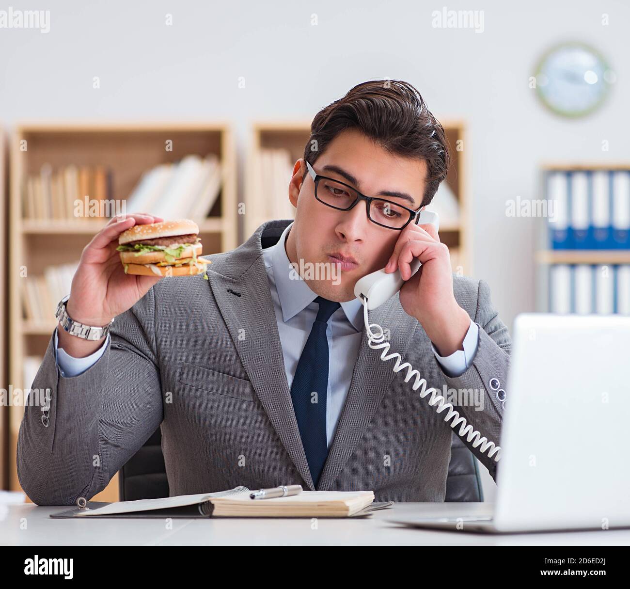 The hungry funny businessman eating junk food sandwich Stock Photo - Alamy