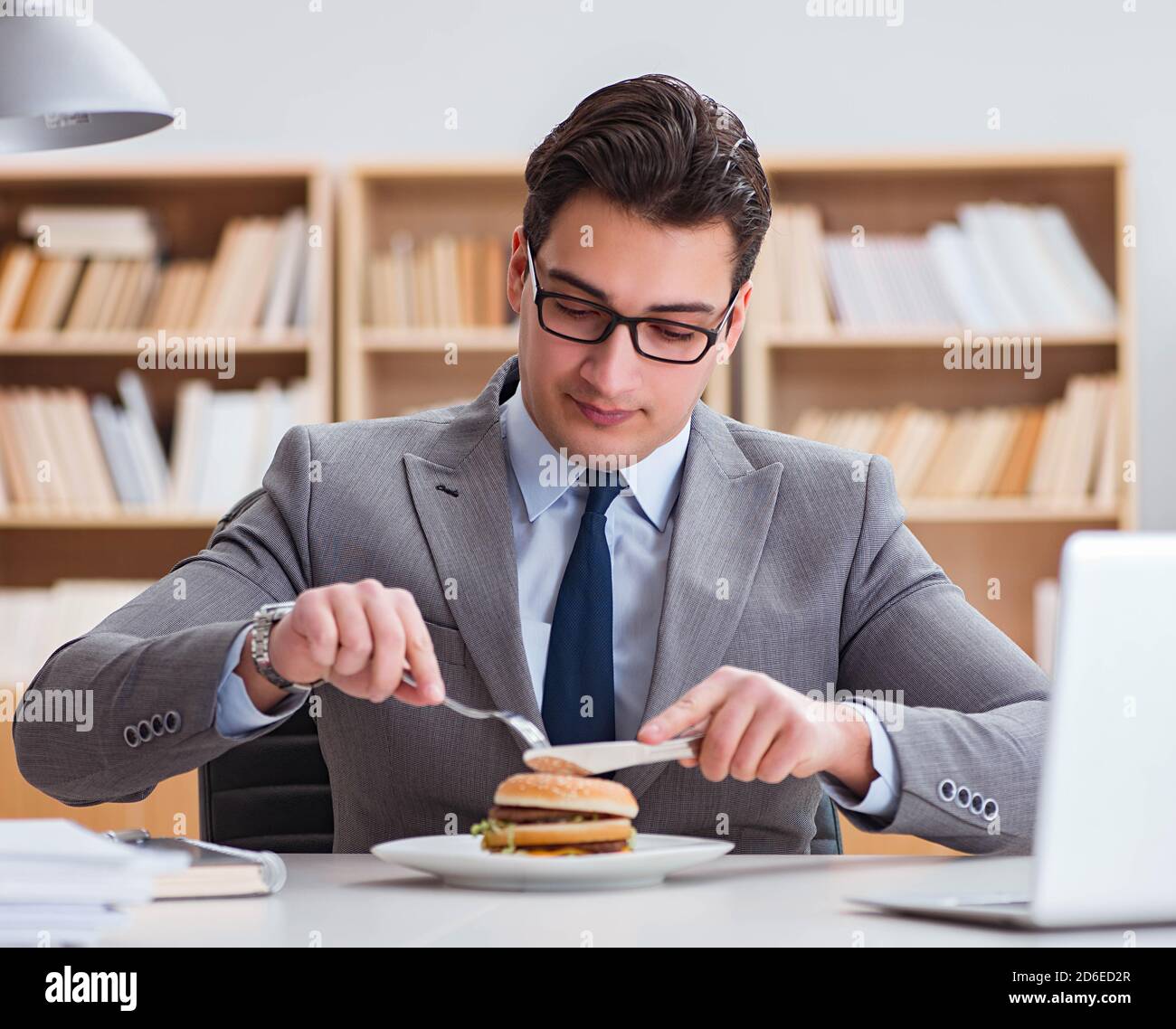 The hungry funny businessman eating junk food sandwich Stock Photo - Alamy