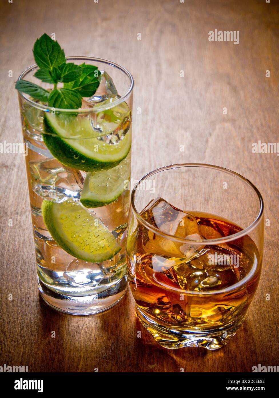 Two glasses of alcohol beverages, gin and tonic and whiskey on the ...
