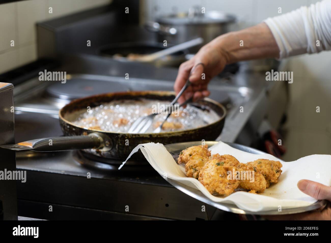 Cod fish fritters being fried in kitchen Stock Photo - Alamy