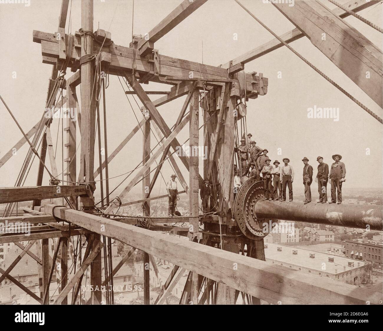Workers standing on axles and beams of the Ferris wheel during ...