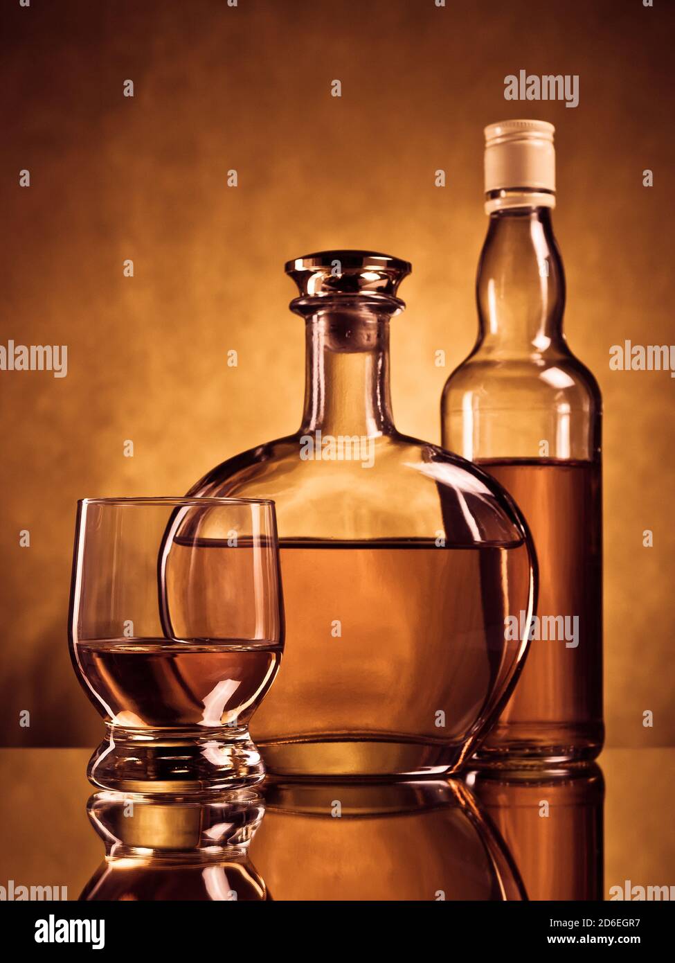 Two bottles of alcohol and a glass on brown grunge background Stock ...