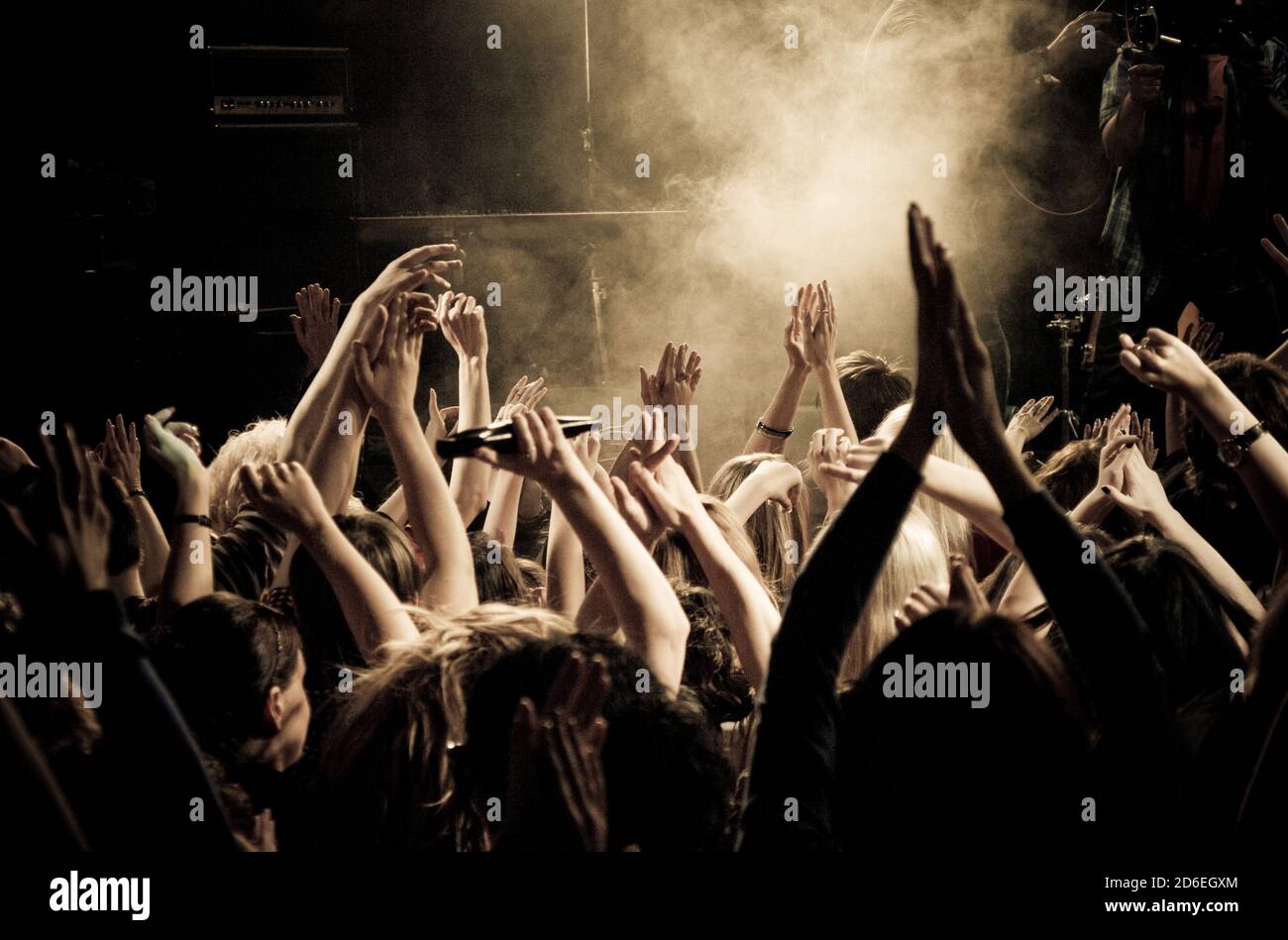 Crowd of music fans raising hands at a concert Stock Photo - Alamy