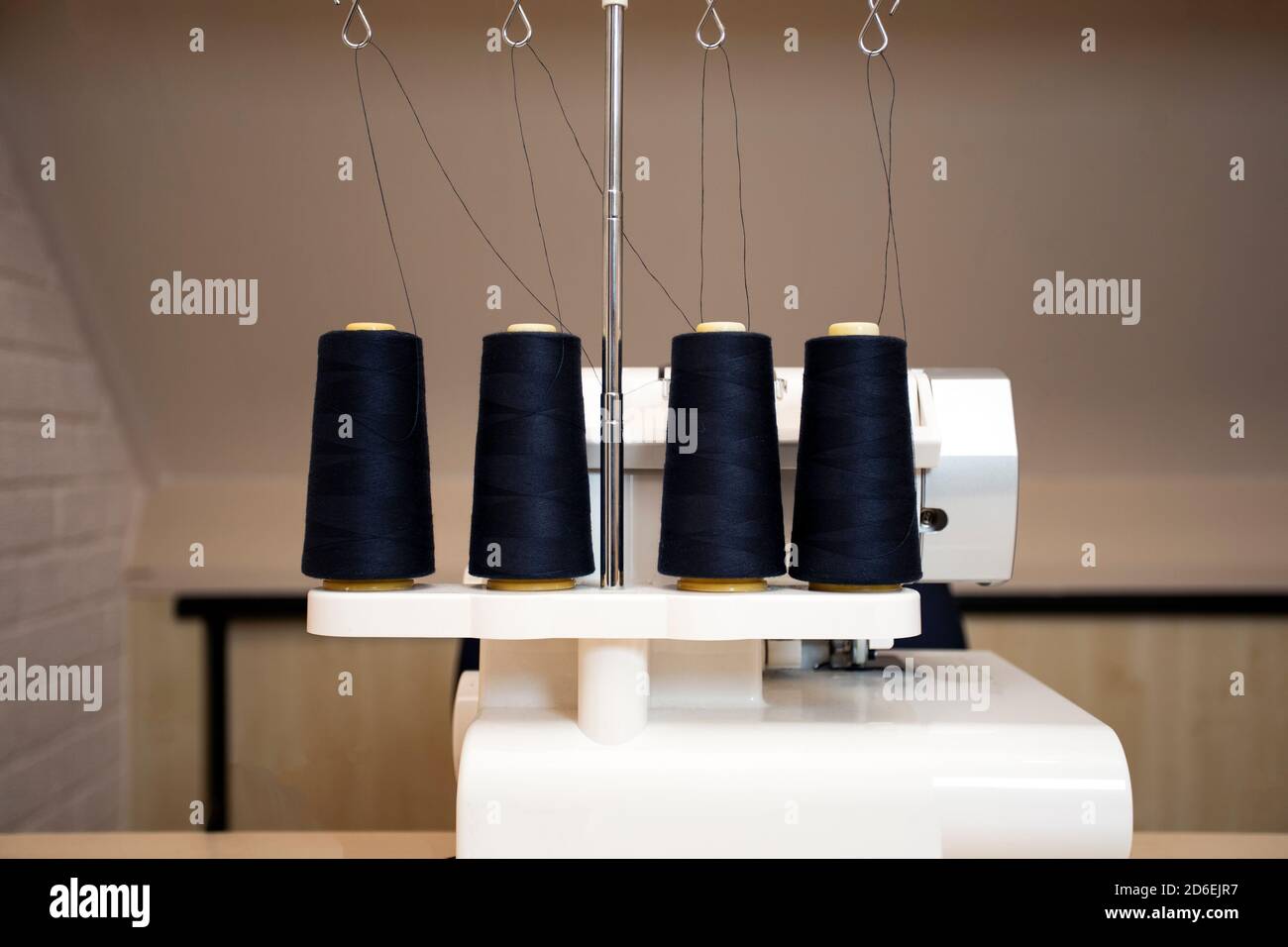 Black thread bobbins on modern overlock white sewing machine ...