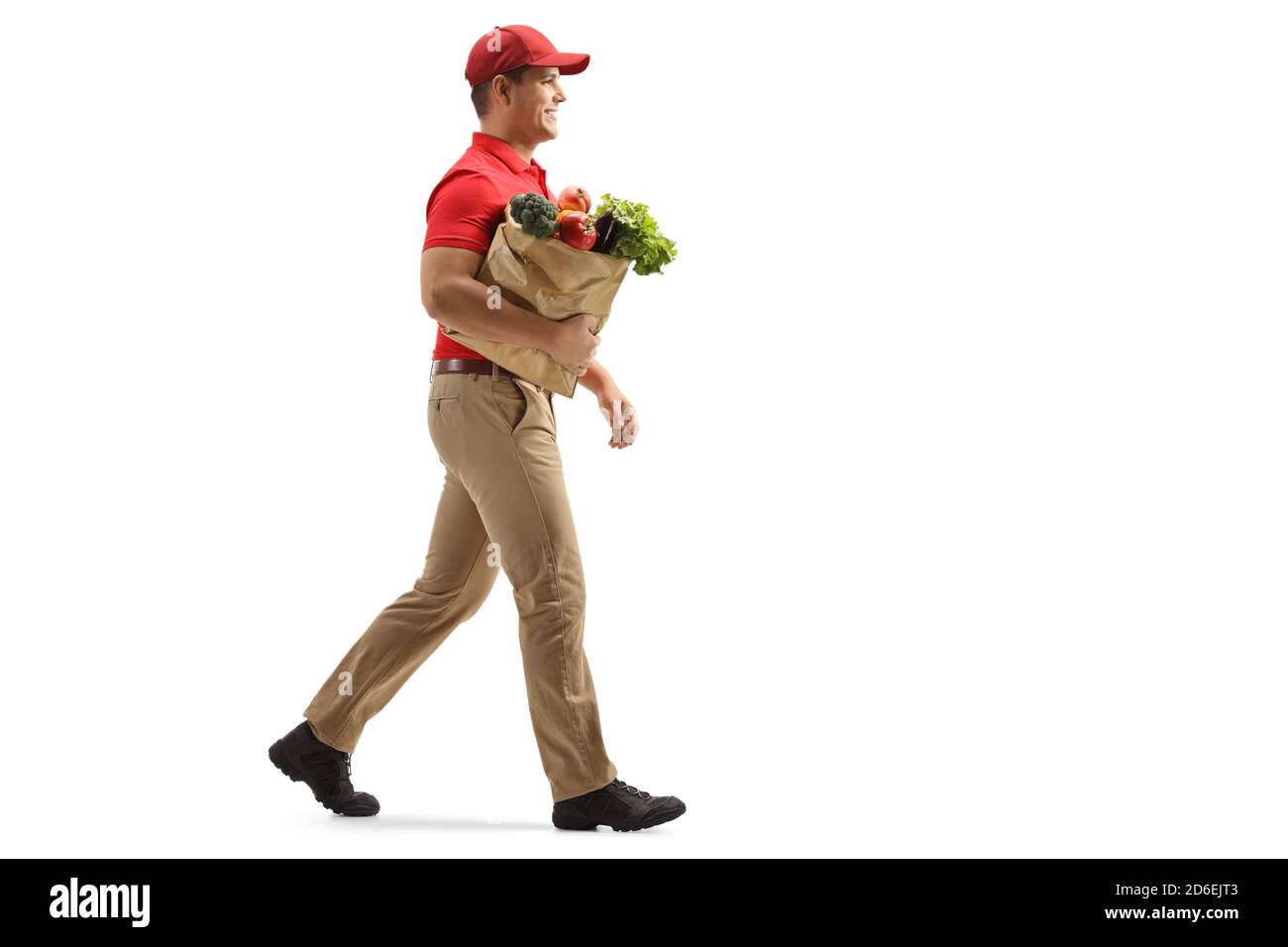 Full length profile shot of a delivery man walking with a bag of ...