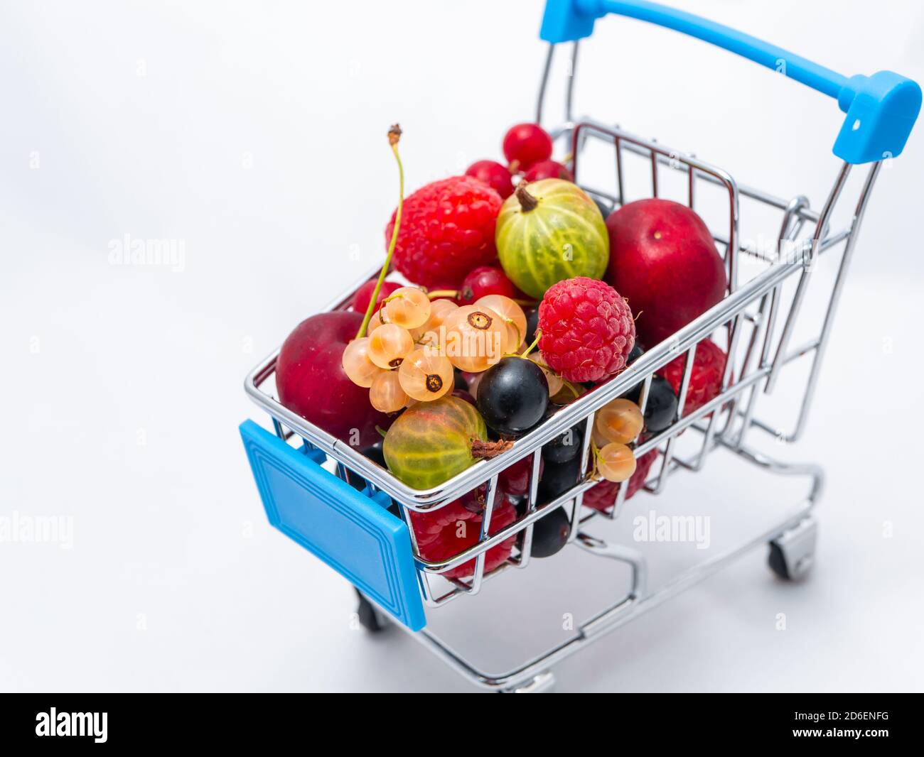 Mini grocery cart filled with fresh vitamin berries isolated on white ...