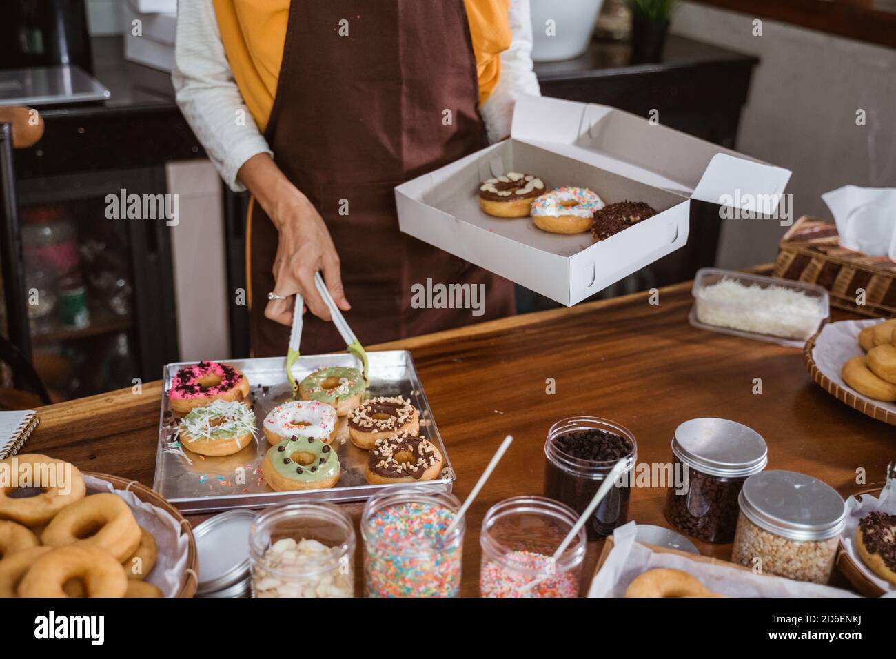 woman's hand using food clips in the kitchen taking the donuts and ...