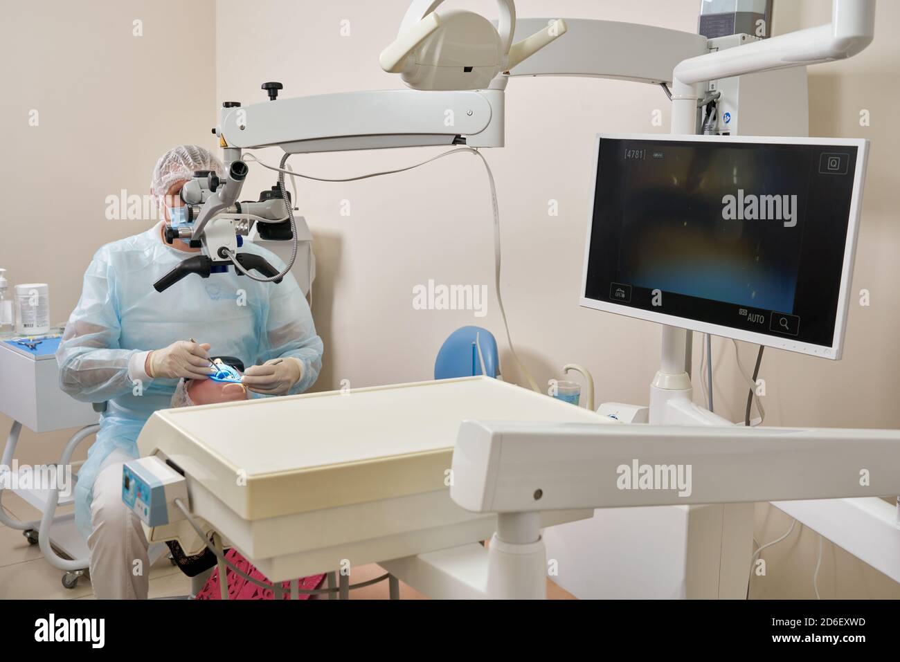 Dentist working with dental microscope and patient at modern dentist ...