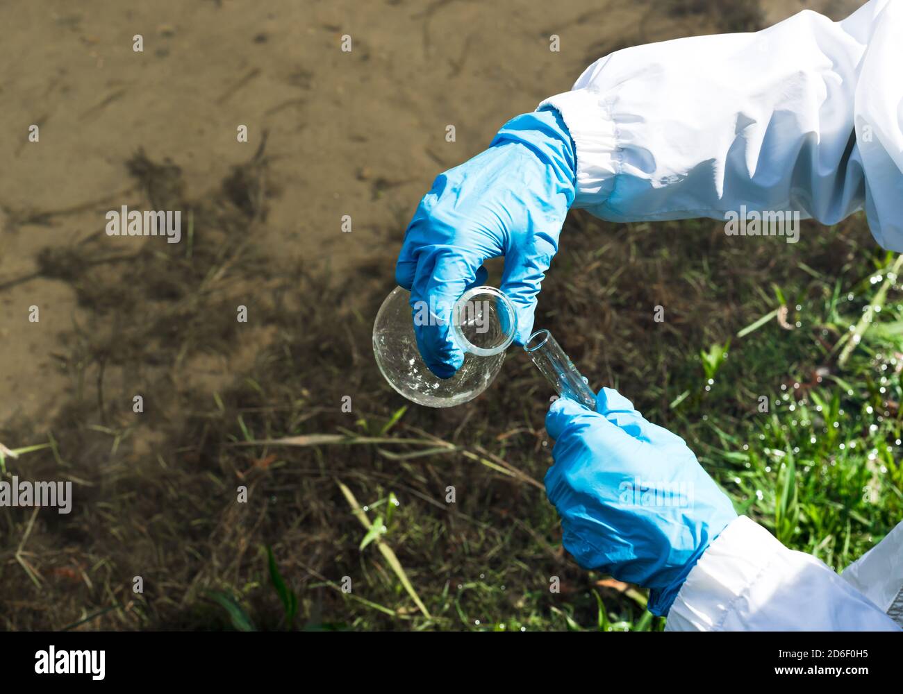 Analysis, water sample from the river, lake. A gloved hand collects ...